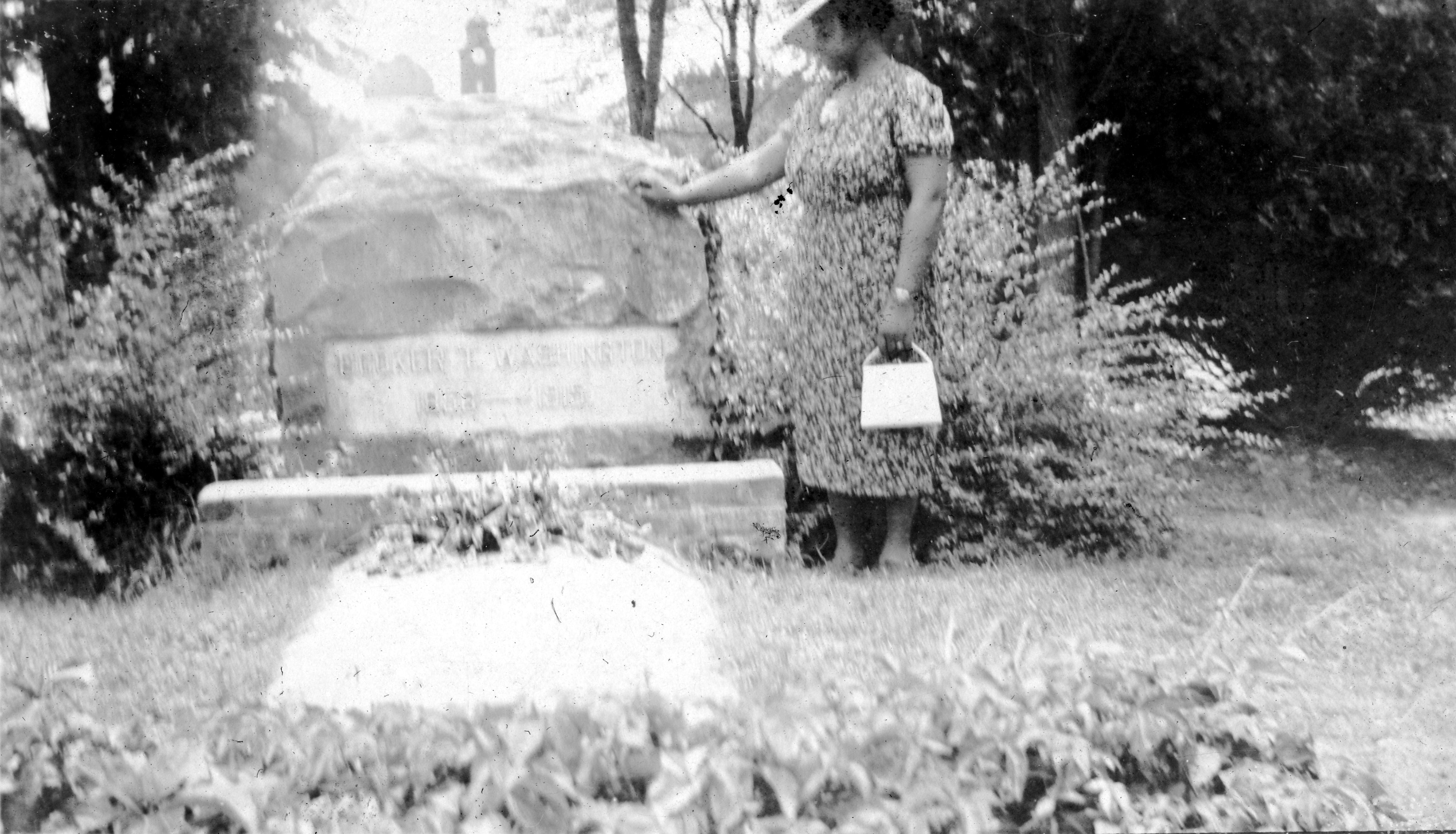 Women standing by Booker T. Washington's tombstone in Tuskegee, Alabama